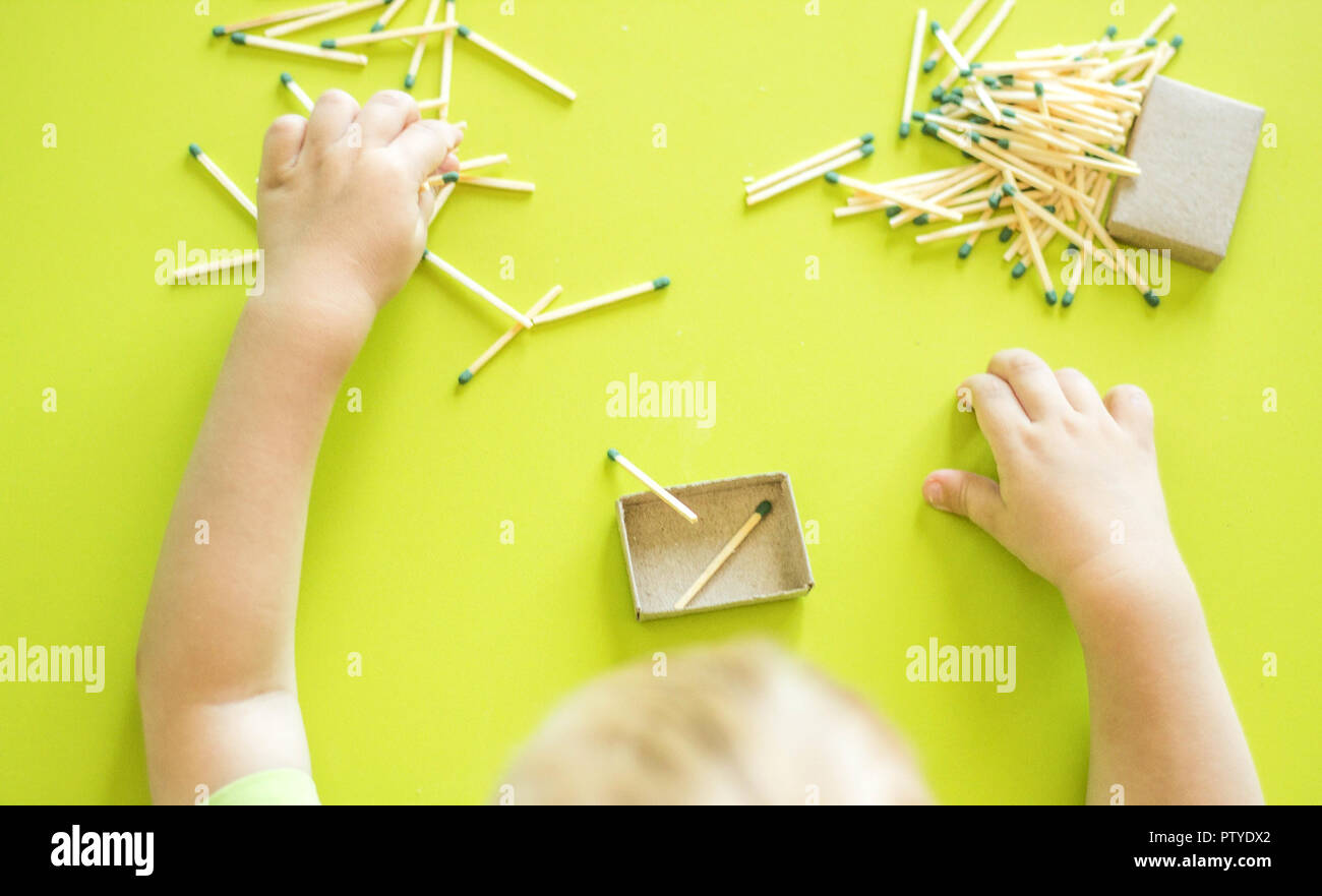 A small child plays with matches, matches matches into boxes, close-ups ...