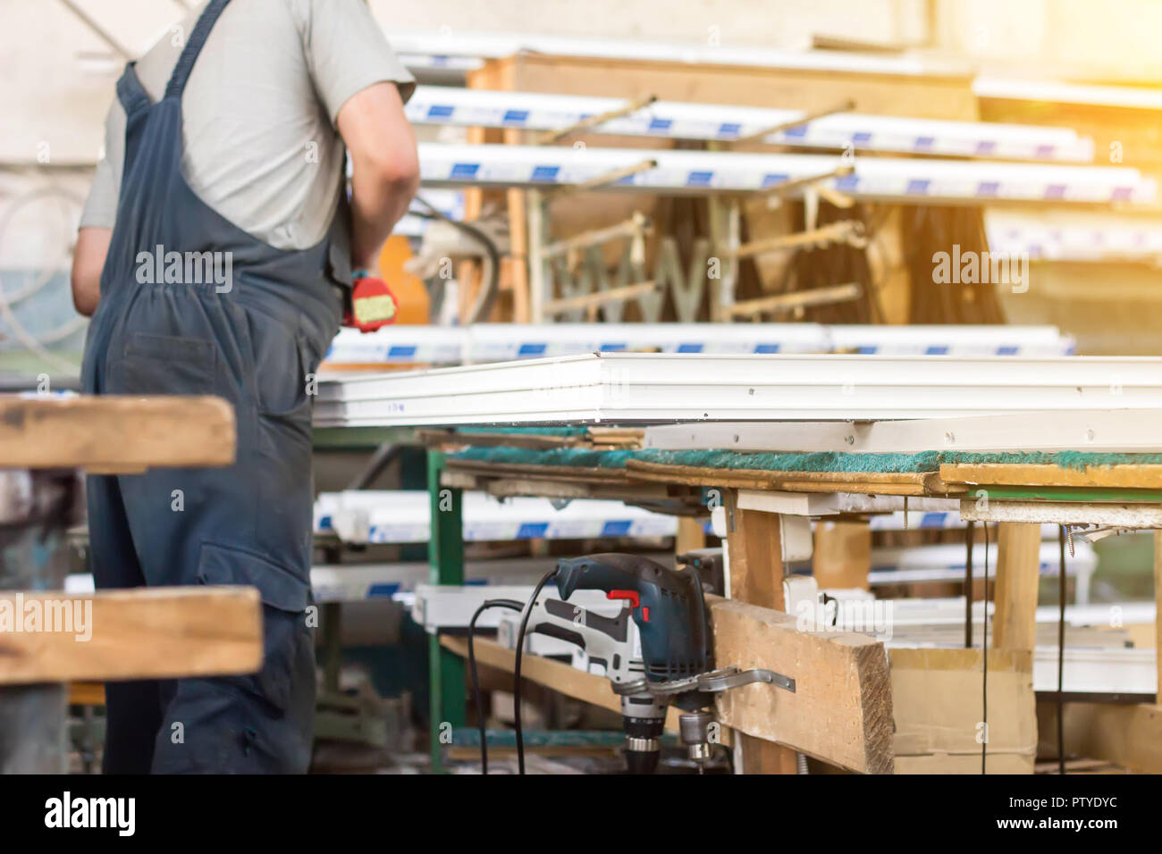 Production of pvc windows, a man collects a pvc window, a screwdriver ...