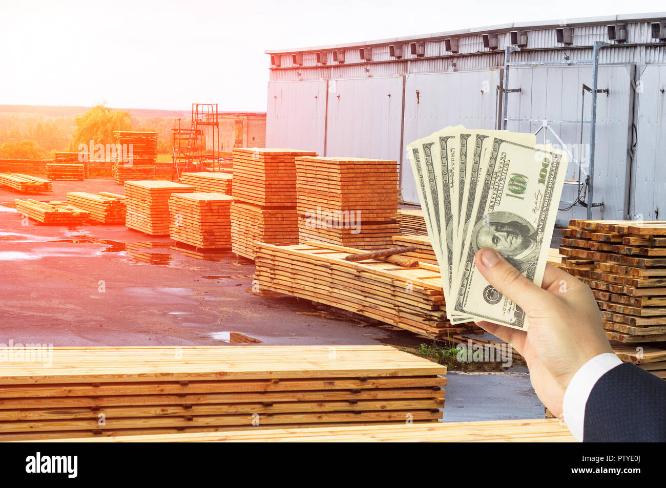Hand with money dollars against the background of a warehouse with ...