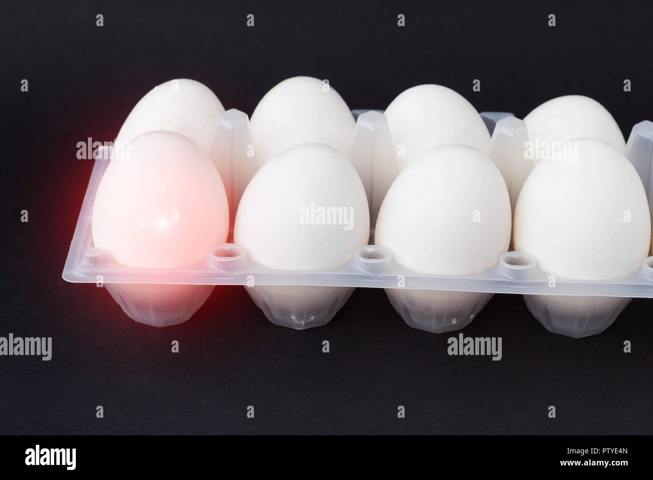 Egg on a black background that is infected with salmonella, close-up ...