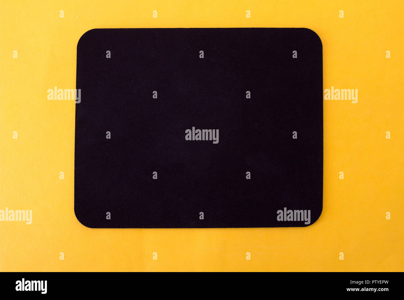 Black computer mat on a yellow background Stock Photo - Alamy