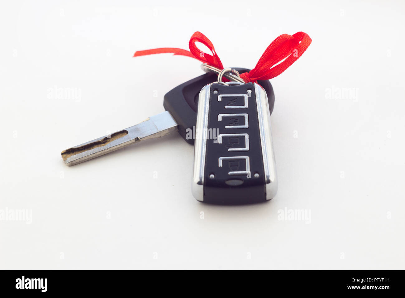 Car keys with red ribbon on white background Stock Photo - Alamy