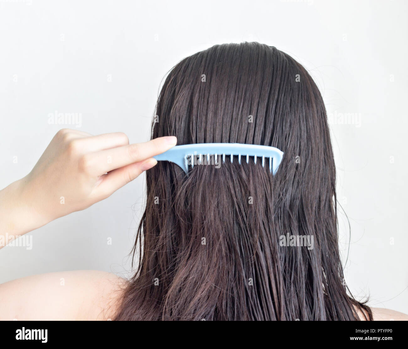 Girl combs long black hair comb, rear view, white background Stock ...