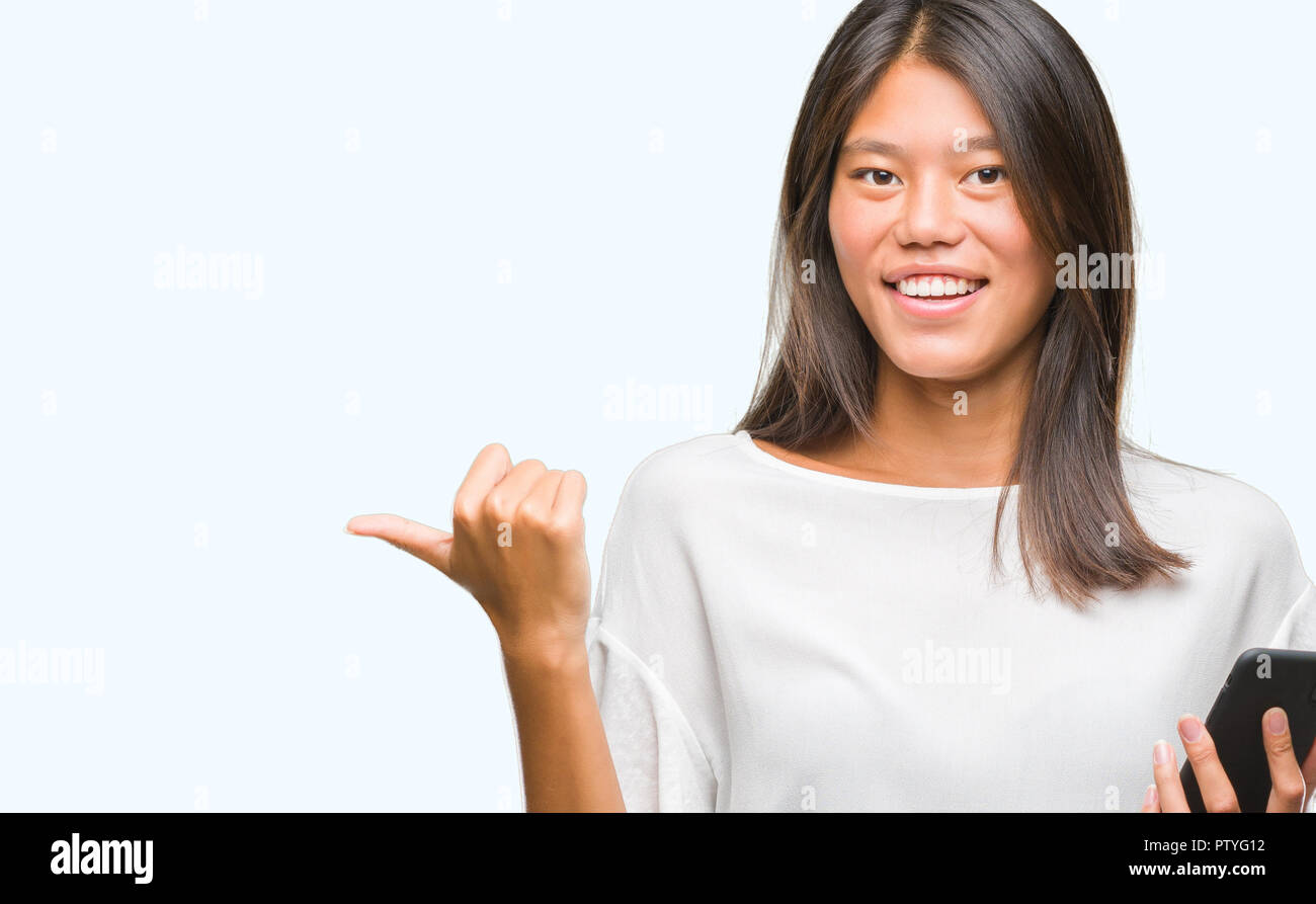 Young asian woman texting using smartphone over isolated background ...