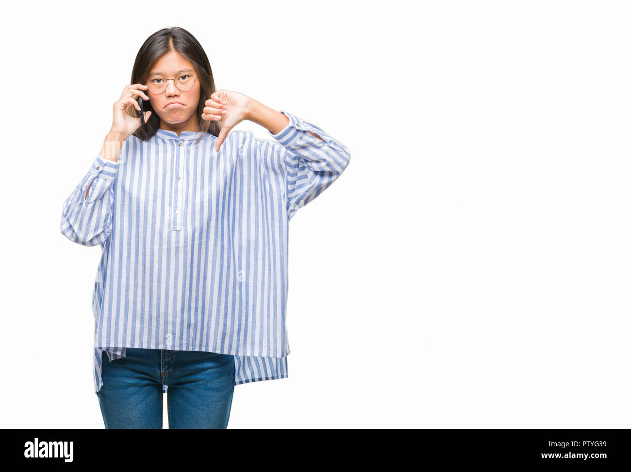 Young asian woman speaking on the phone over isolated background with ...