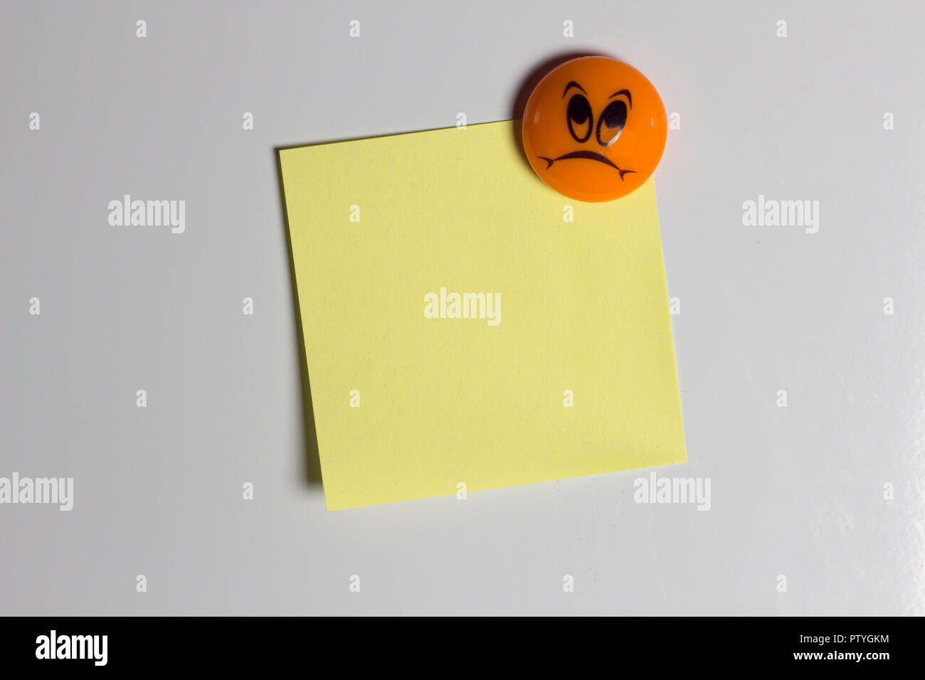 Yellow sticker on the fridge with a sad face Stock Photo - Alamy