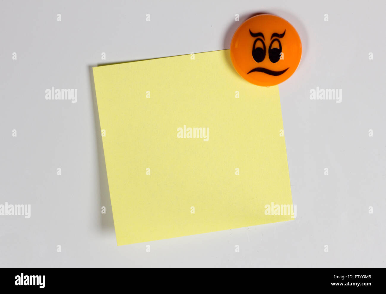 Yellow sticker on the fridge with a sad face Stock Photo - Alamy
