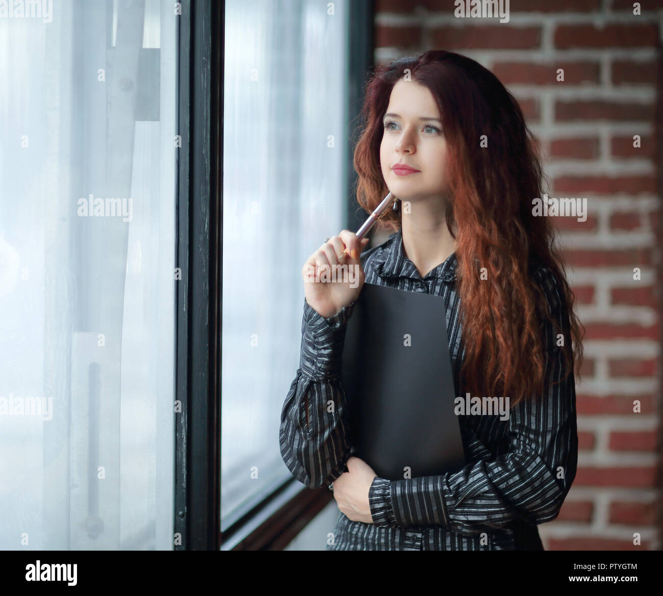 successful business woman looking out the window of a modern office ...