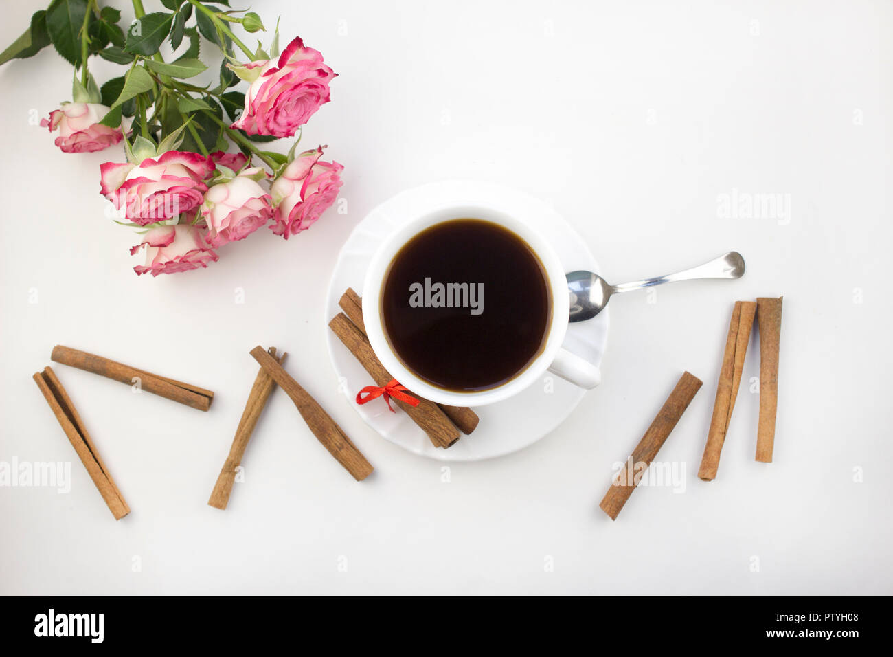 A cup of coffee cinnamon and roses on a white background Stock Photo ...
