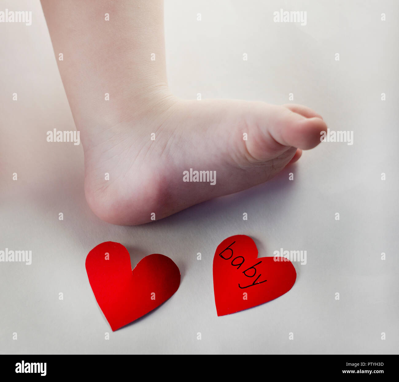 Baby leg and two hearts on a white background Stock Photo - Alamy