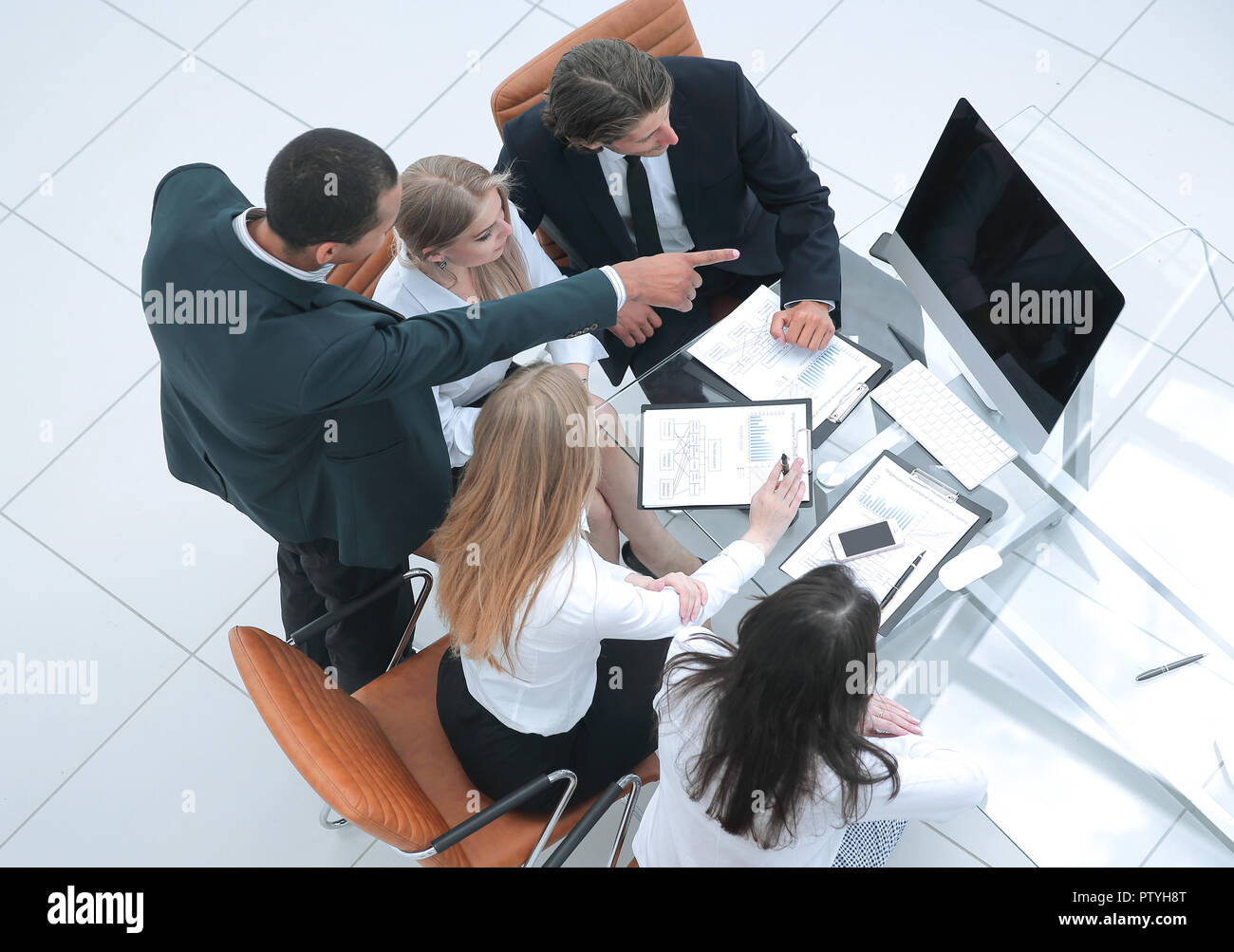 Business team looking at documents in the office with the Manager Stock ...