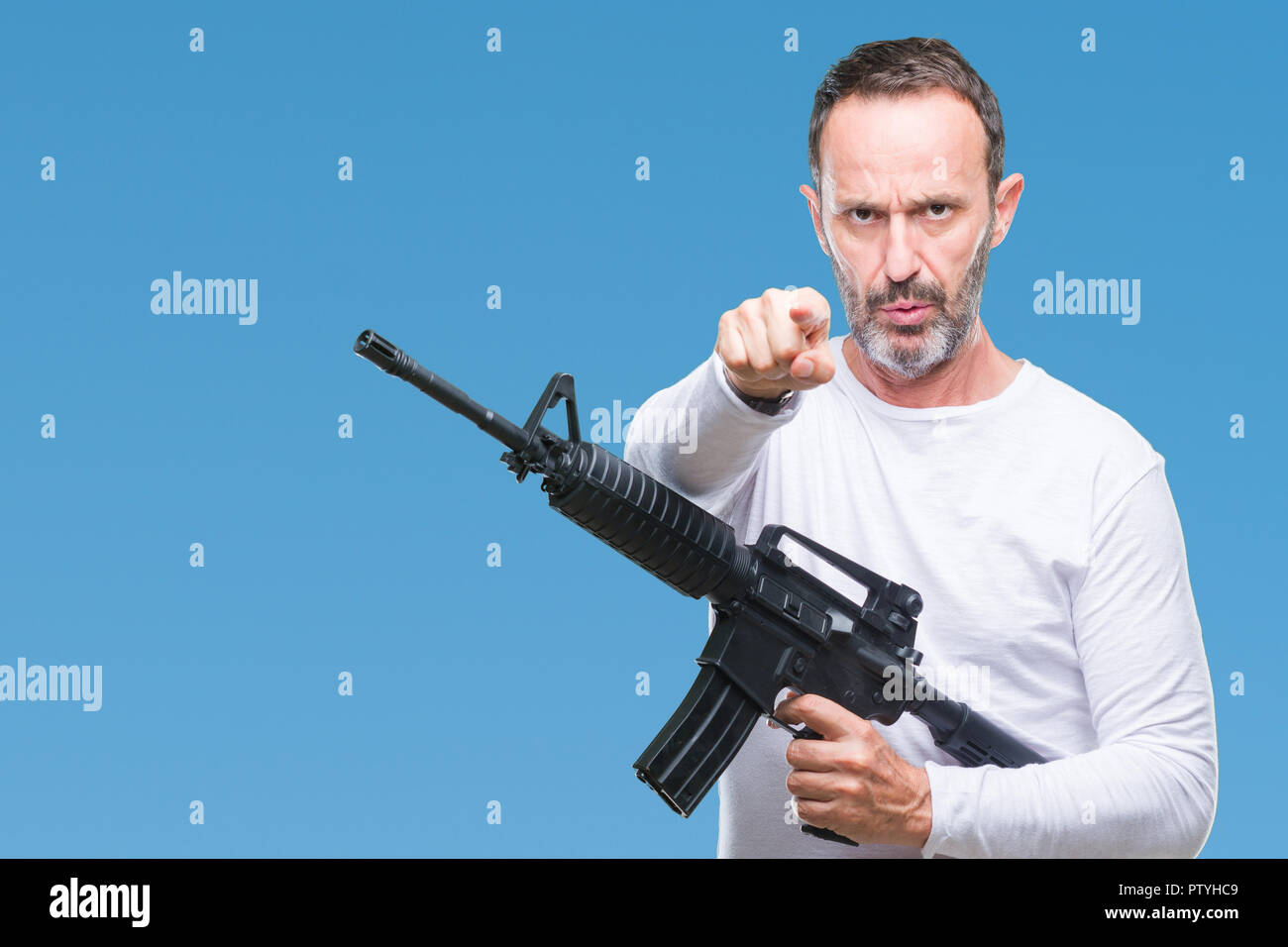 Middle age senior hoary criminal man holding gun weapon over isolated ...