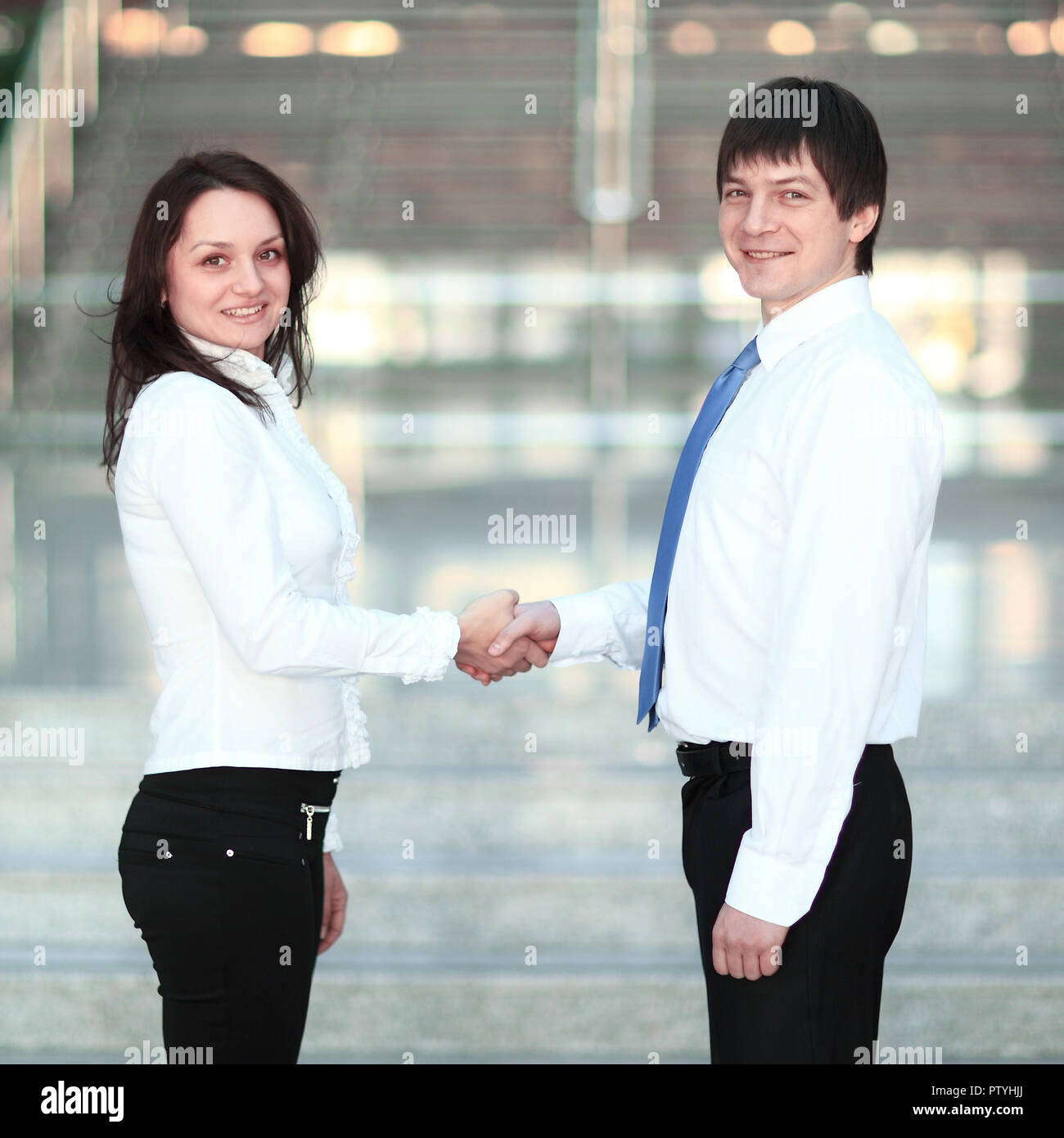 welcome handshake of young business partners on the background of the office Stock Photo - Alamy