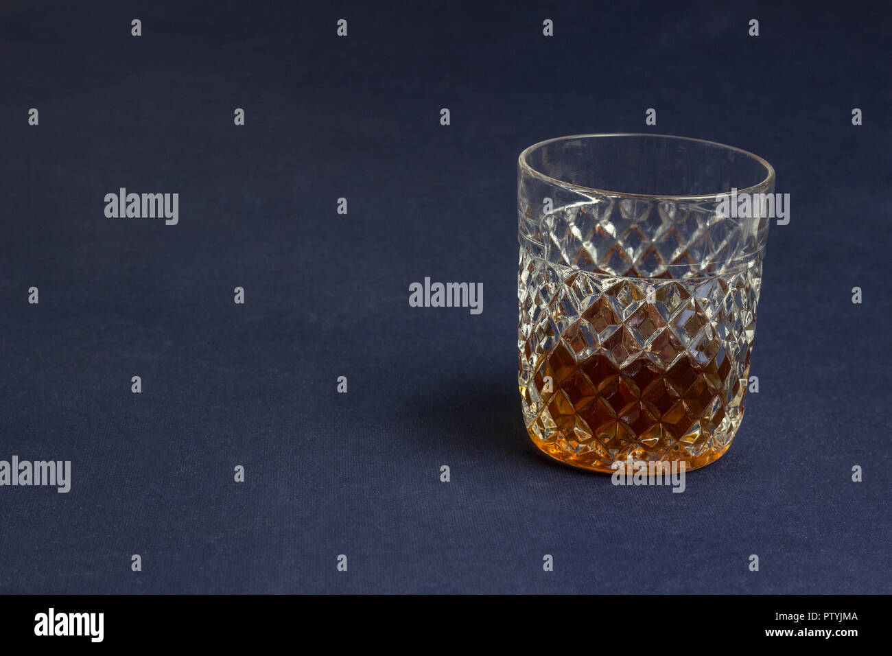 Glass with alcohol on a blue background Stock Photo - Alamy