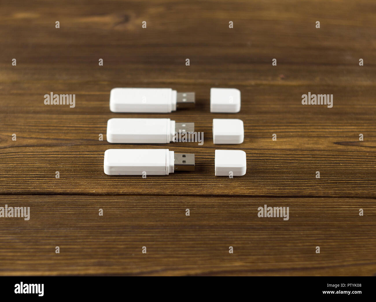 three white USB flash drives on a wooden background Stock Photo - Alamy