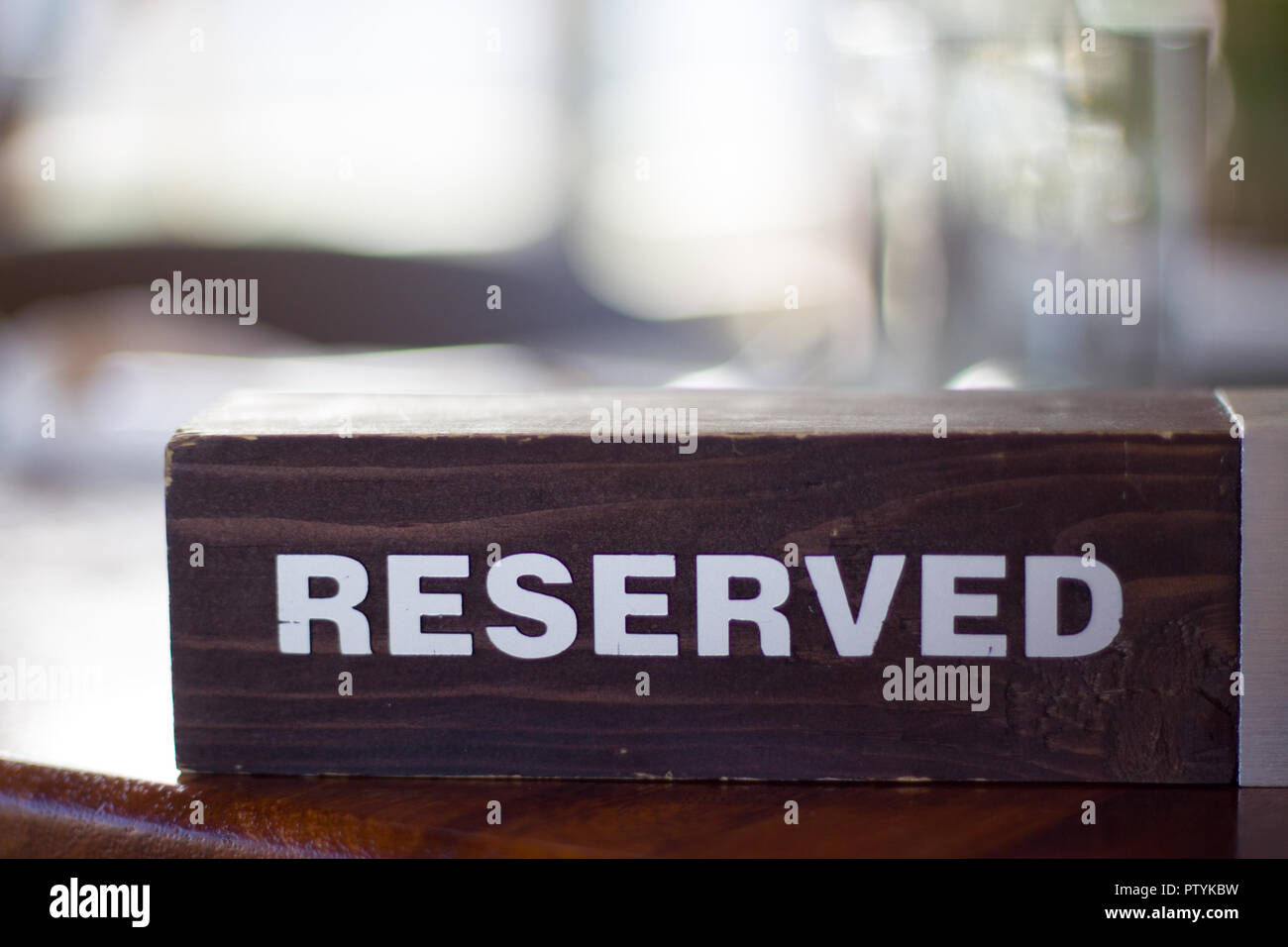 Reserved wooden Card Plate on the Table with Blurry background ...