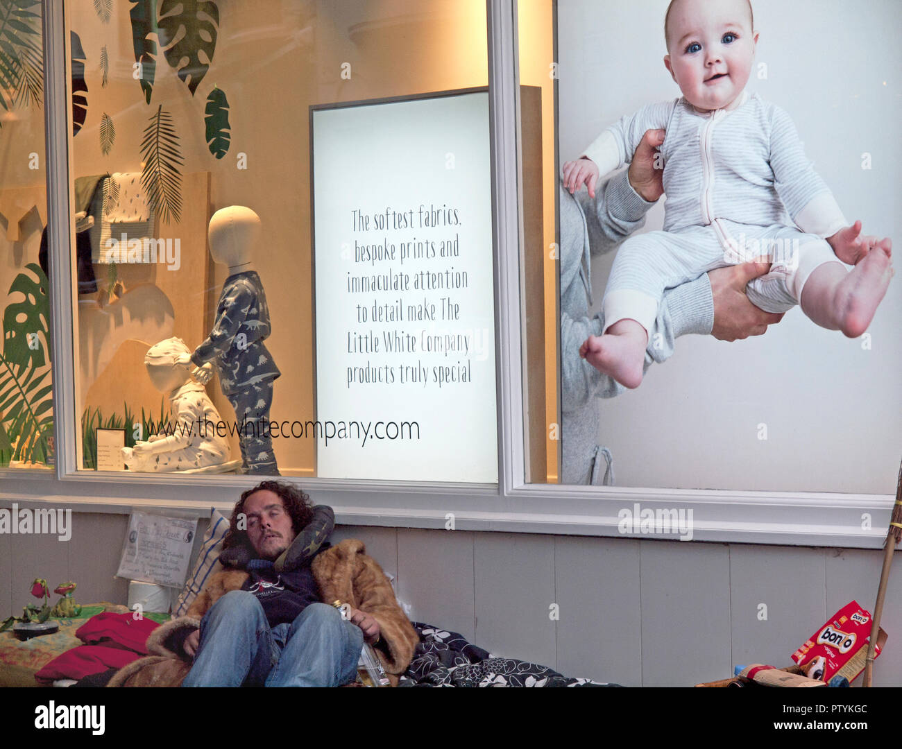 A homeless man sleeps in front of a shop window display in Brighton ...