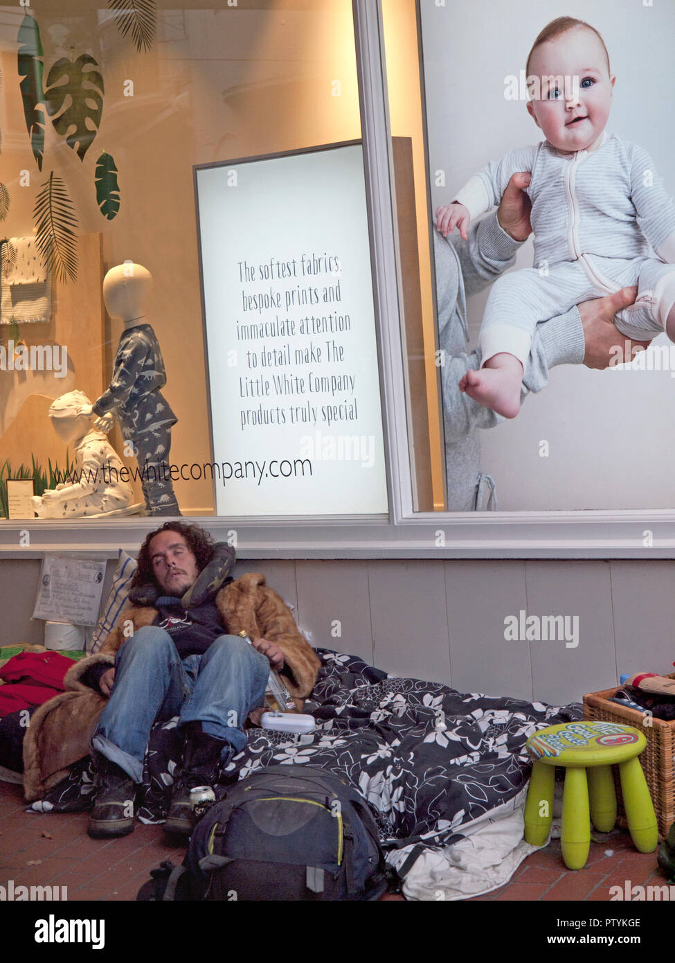 A homeless man sleeps in front of a shop window display in Brighton ...
