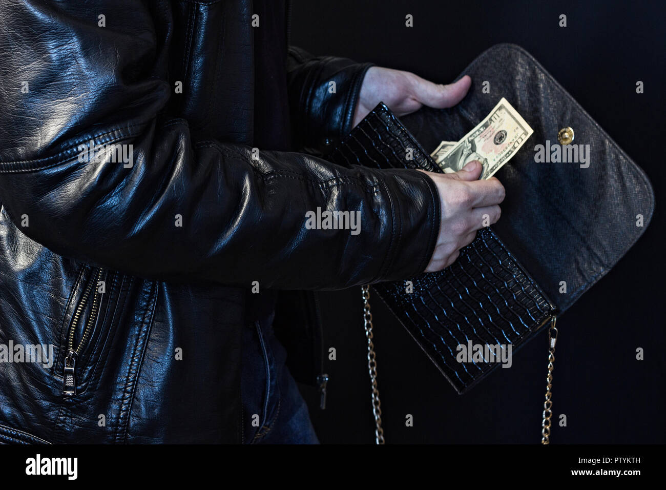 A man steals money from a female bag, black background, close-up Stock ...