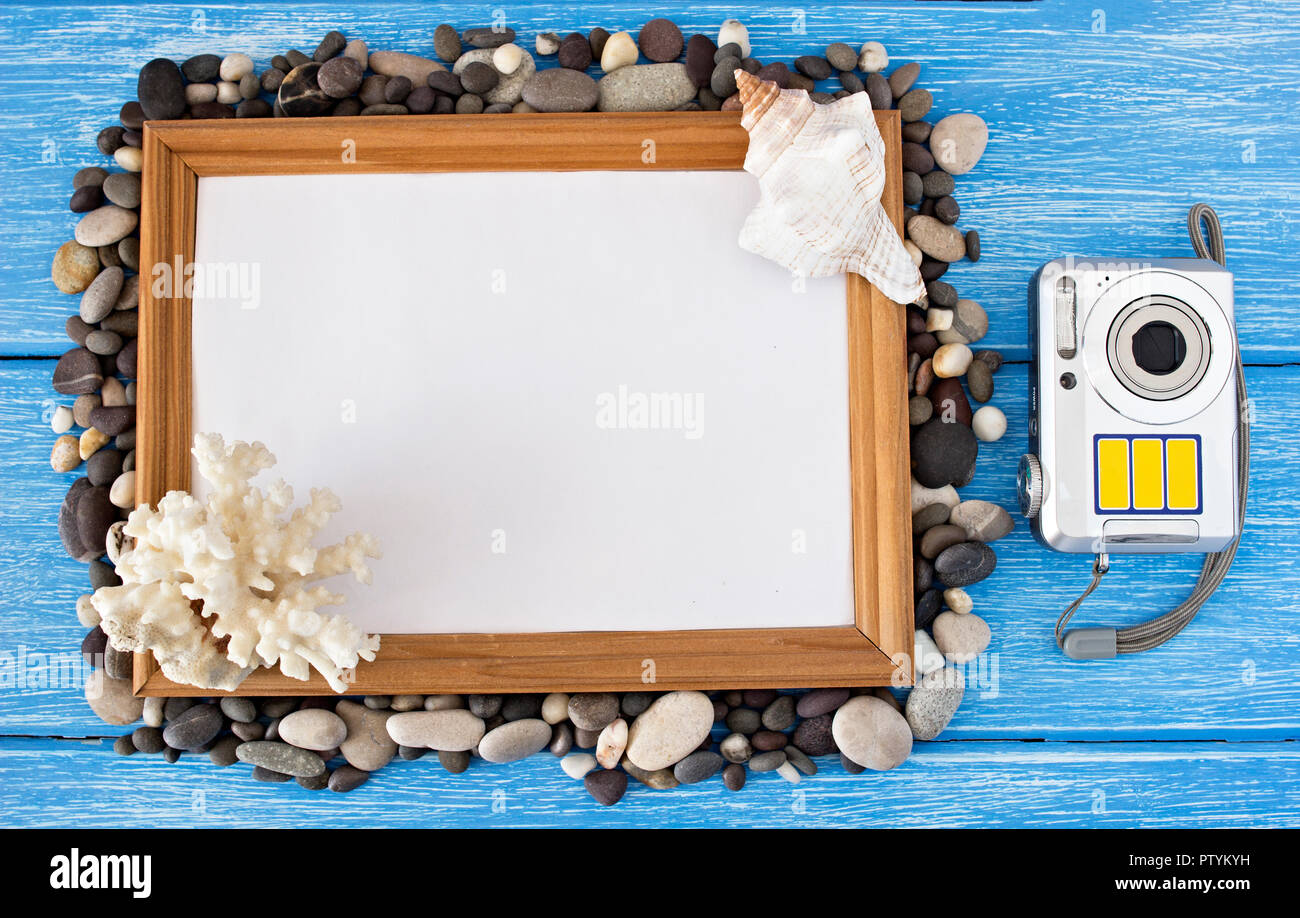 frame on a blue wooden background and sea shells and stones, camera ...