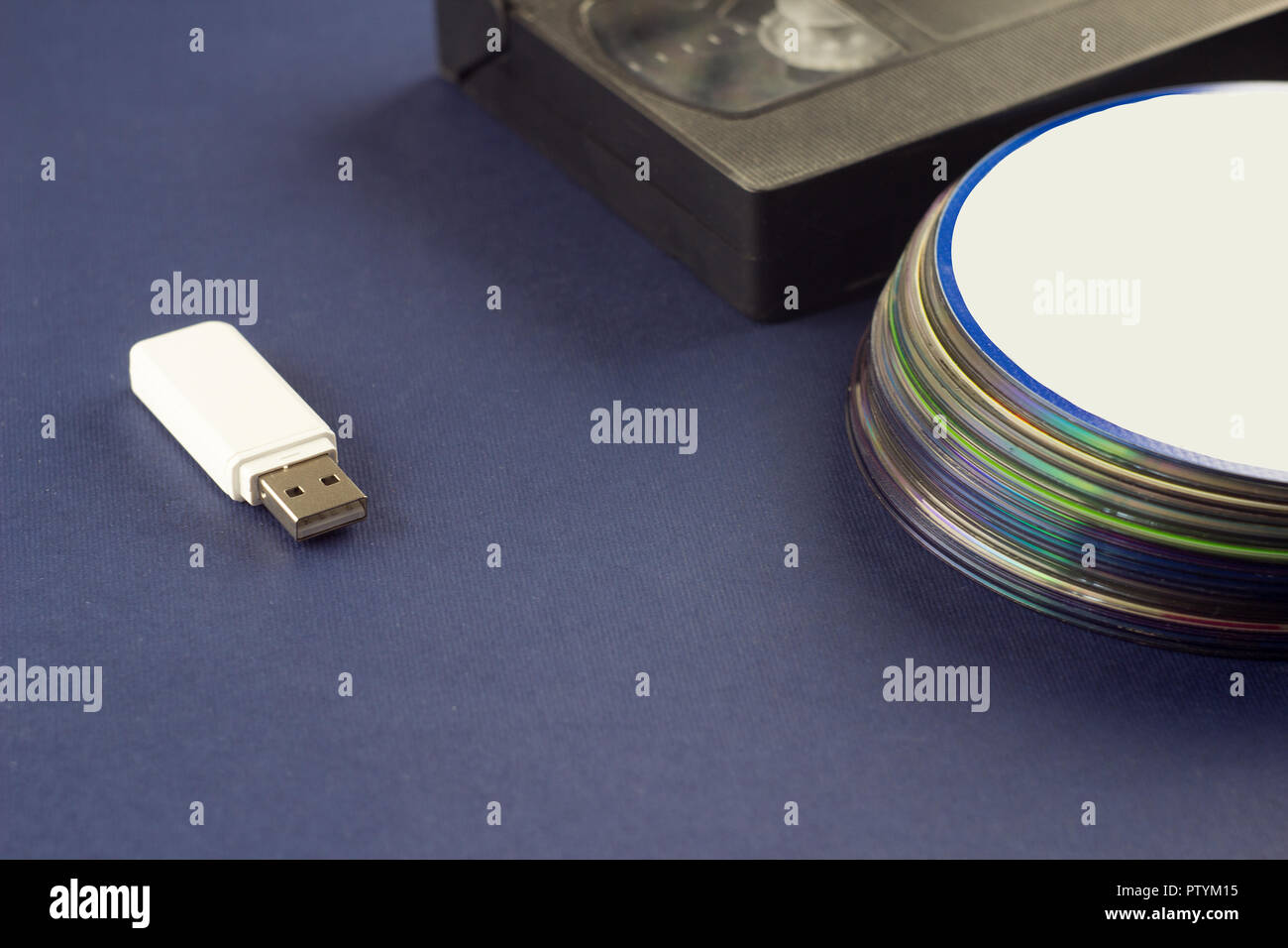 White flash drive on a blue background video cassette and compact discs ...