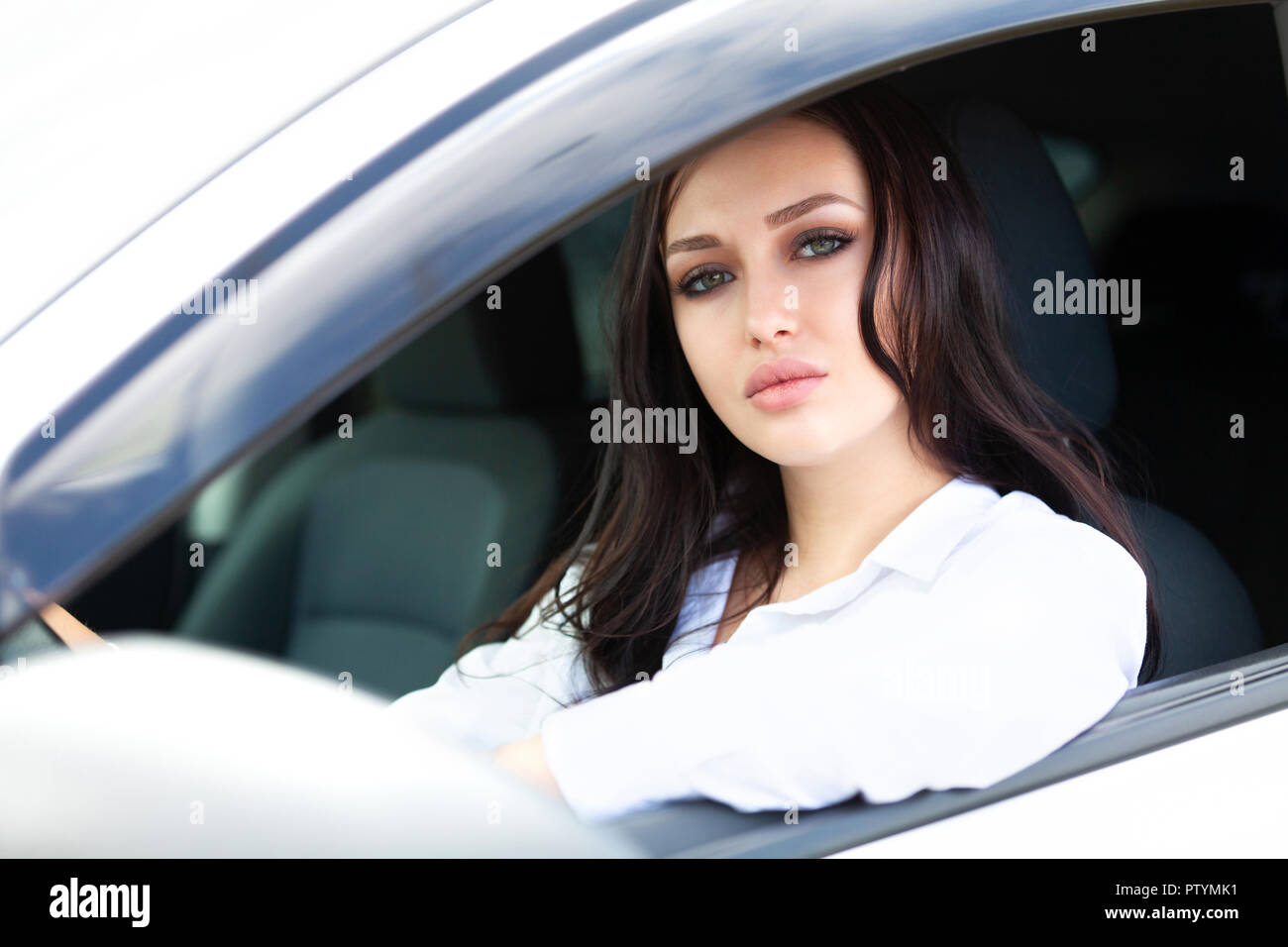 Pretty girl driver in a white car Stock Photo - Alamy