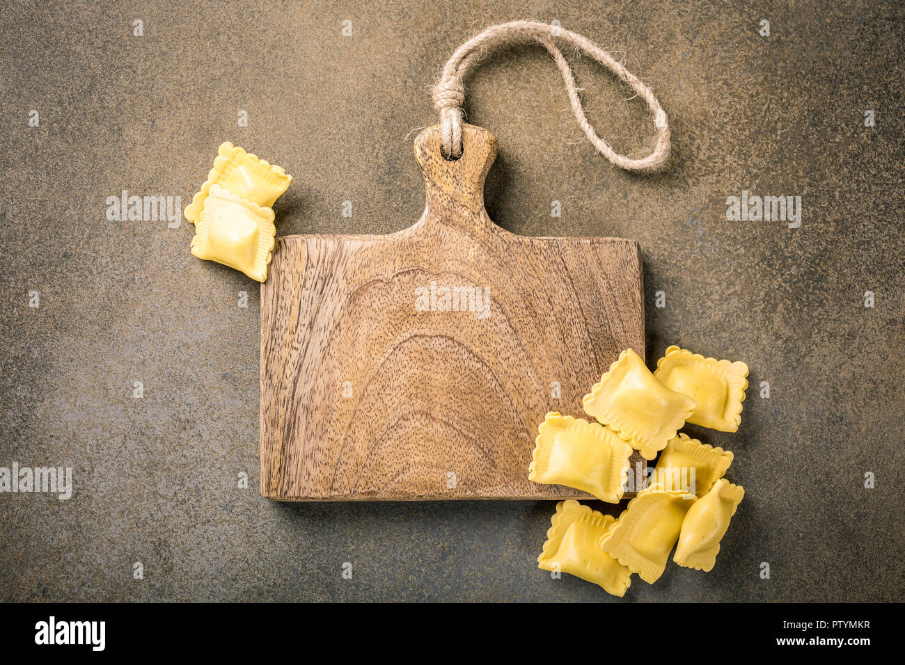 Fresh homemade italian filled square pasta ravioli on wooden cutting ...