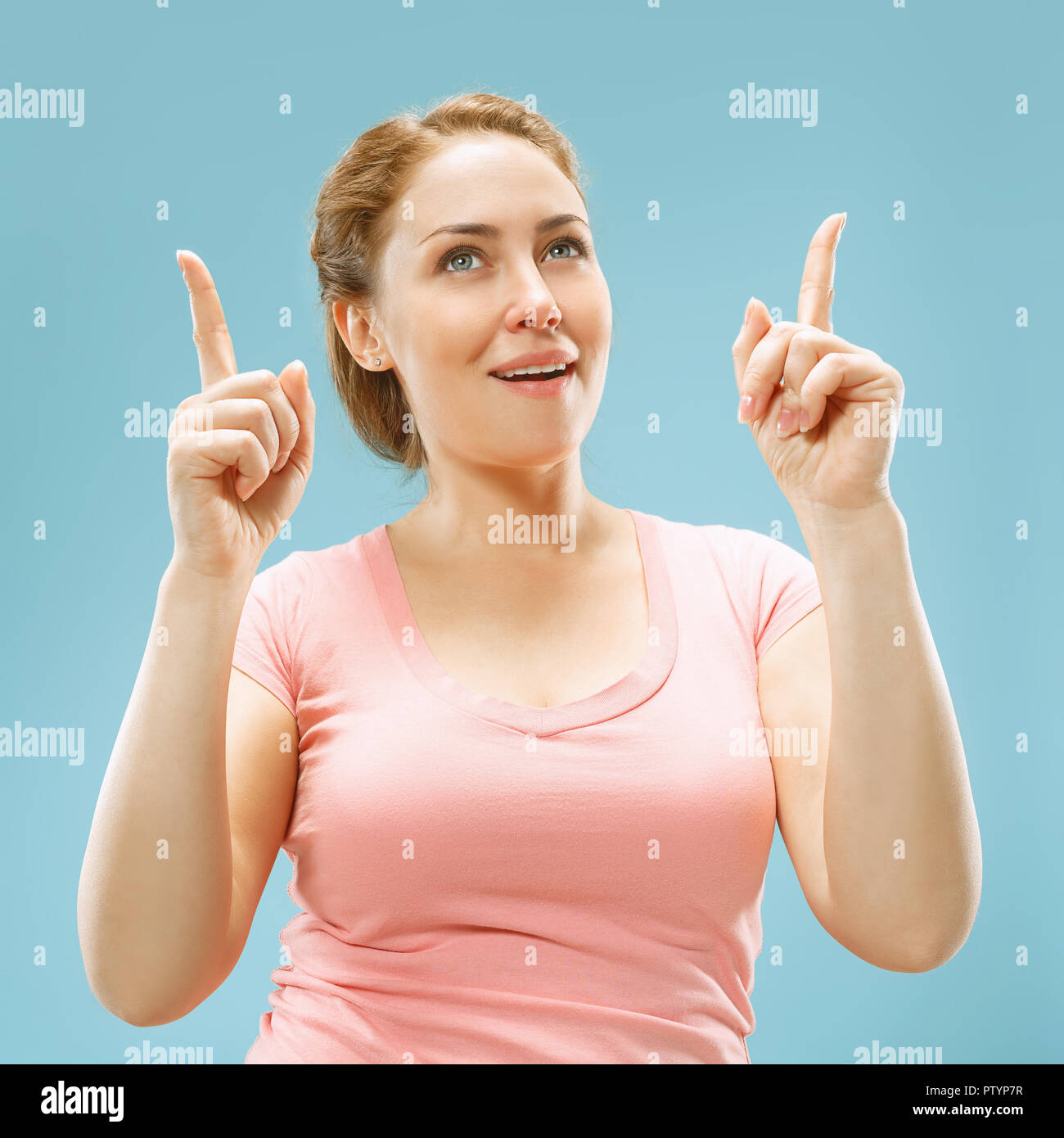 Wow. Beautiful female half-length portrait isolated on blue studio ...