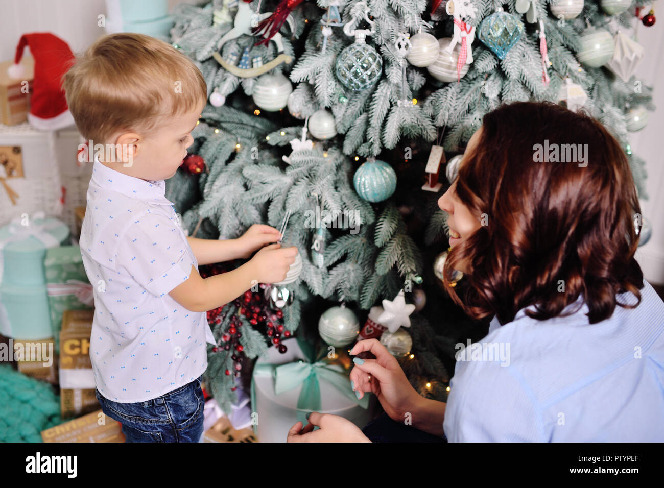 Mom and his young son decorate the tree in a cozy house Stock Photo - Alamy