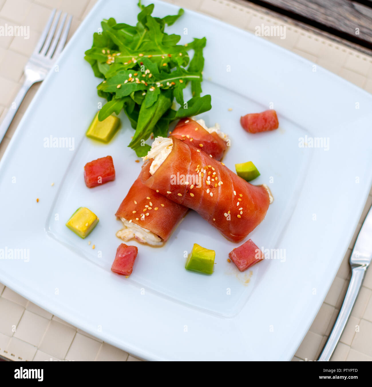 rolls of tuna with crab meat with slices of avocado and greens Stock ...