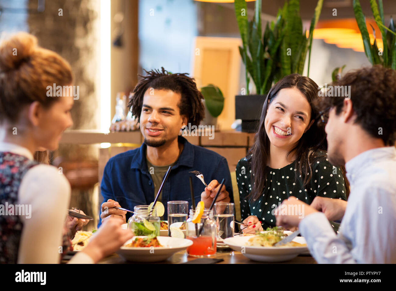 happy friends eating at restaurant Stock Photo - Alamy