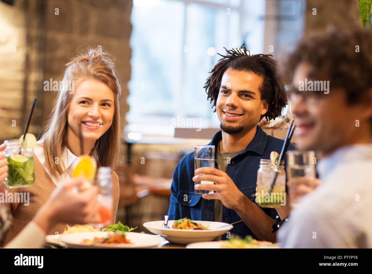 happy friends eating at bar or restaurant Stock Photo - Alamy