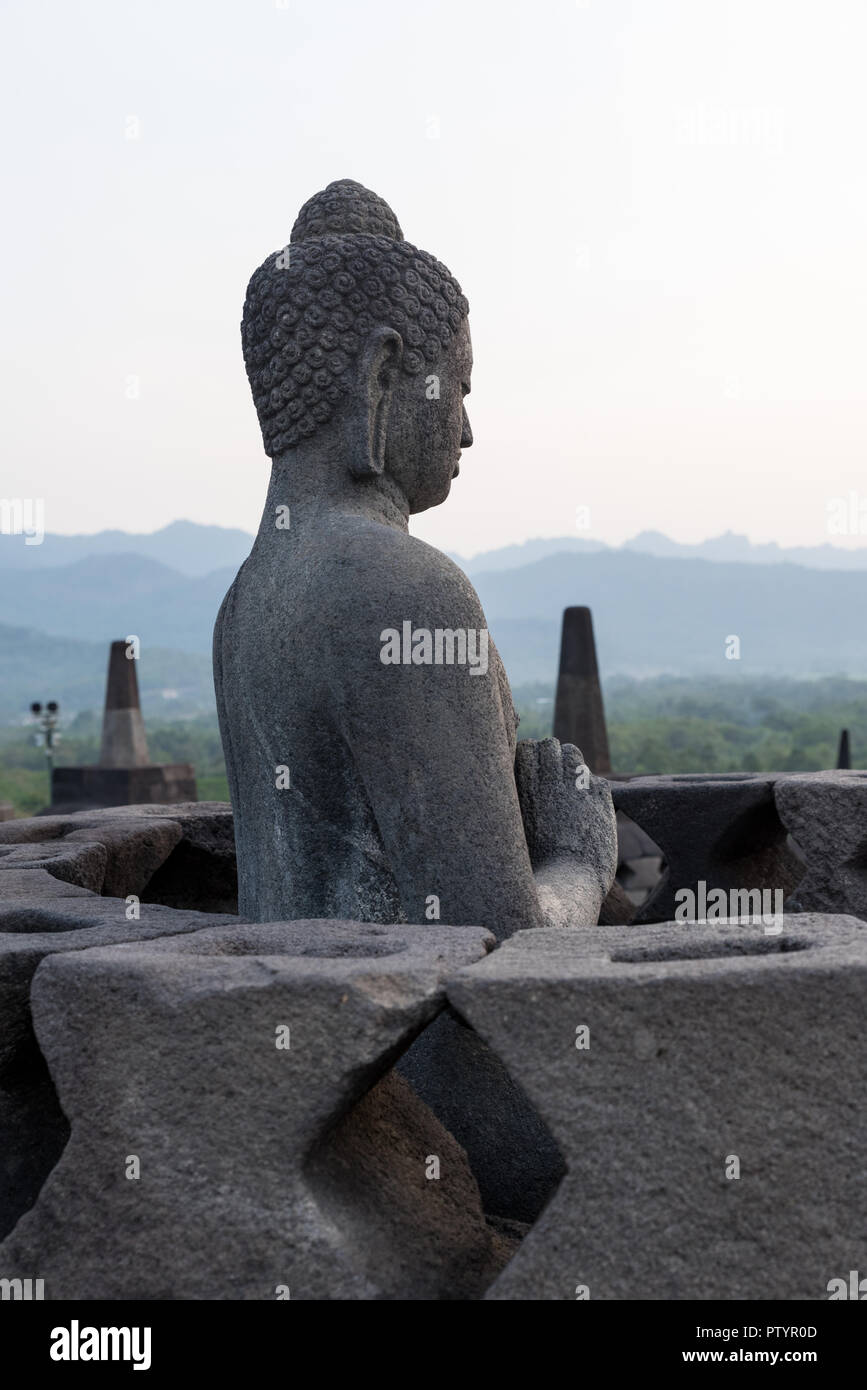 A Buddha statue in a buddhist complex in Java at sunset, Indonesia ...