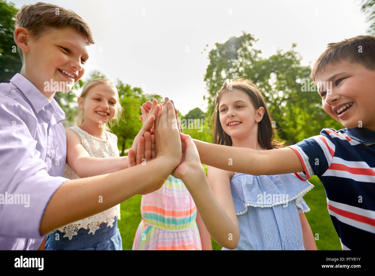 group of happy kids making high five outdoors Stock Photo - Alamy