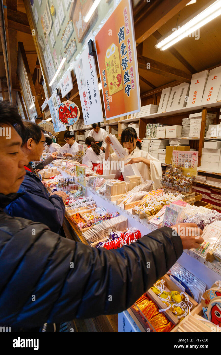 Japanese new year, shogatsu. Man at busy counter of shrine office ...