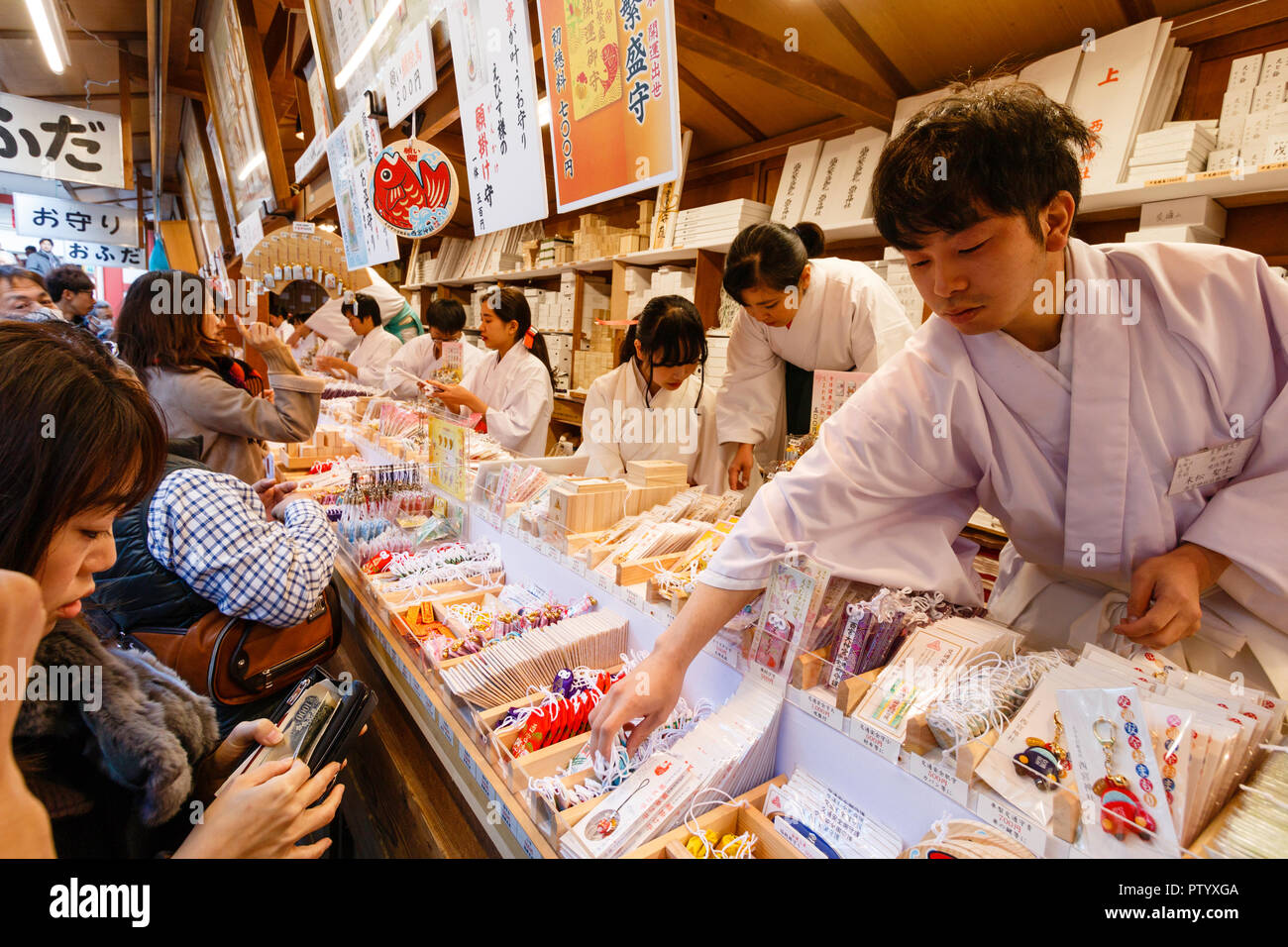 Japanese new year, shogatsu. Man at busy counter of shrine office ...