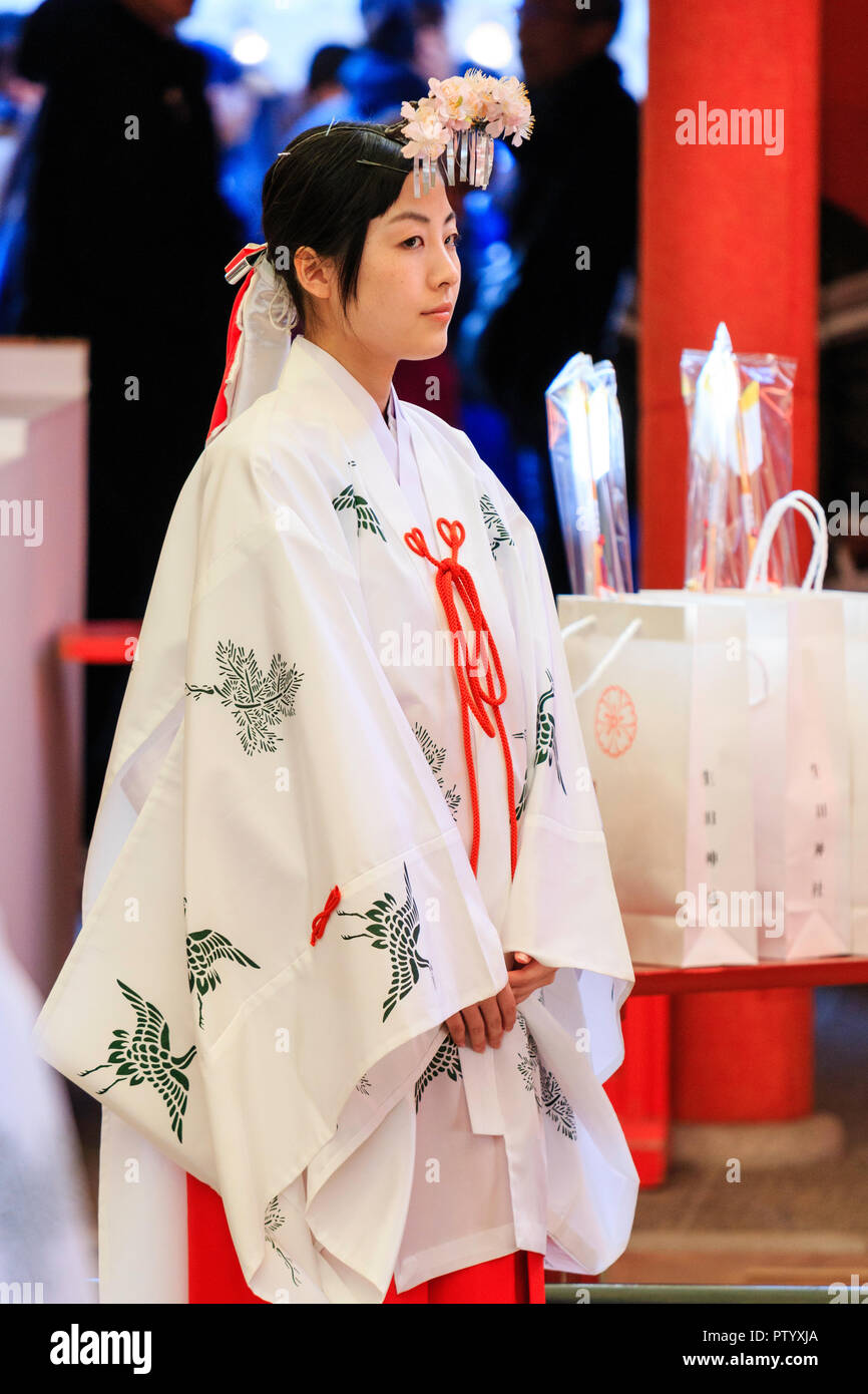 Japanese new year, shogatsu. Shrine Maiden, Miko, stands by ceremonial ...