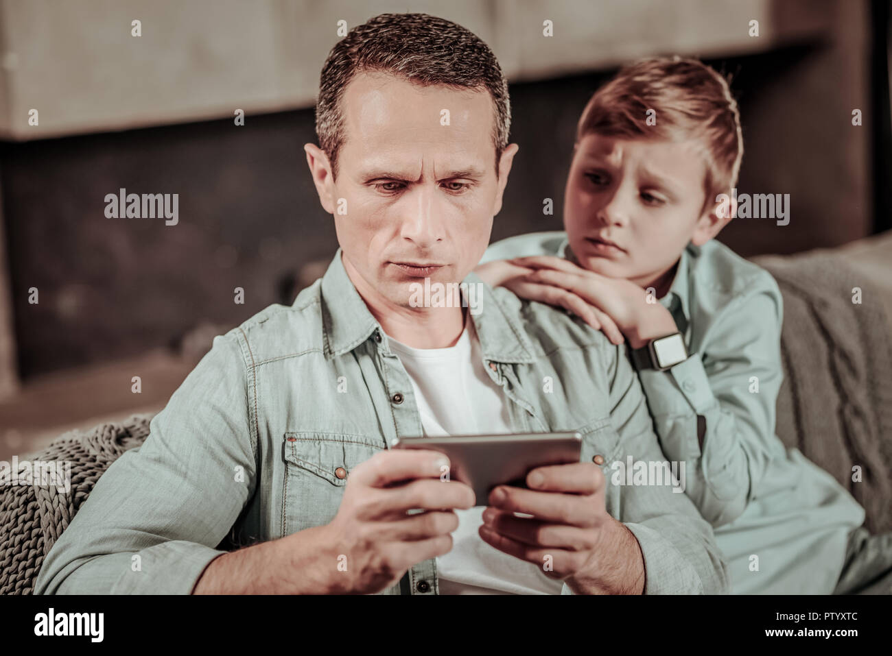 Concentrated male person using gadget for watching film Stock Photo - Alamy
