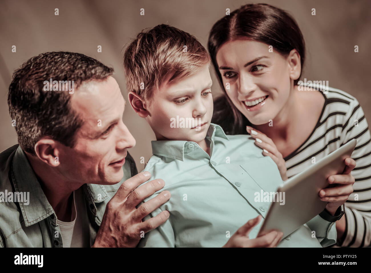 Positive delighted mother cheering her son up Stock Photo - Alamy