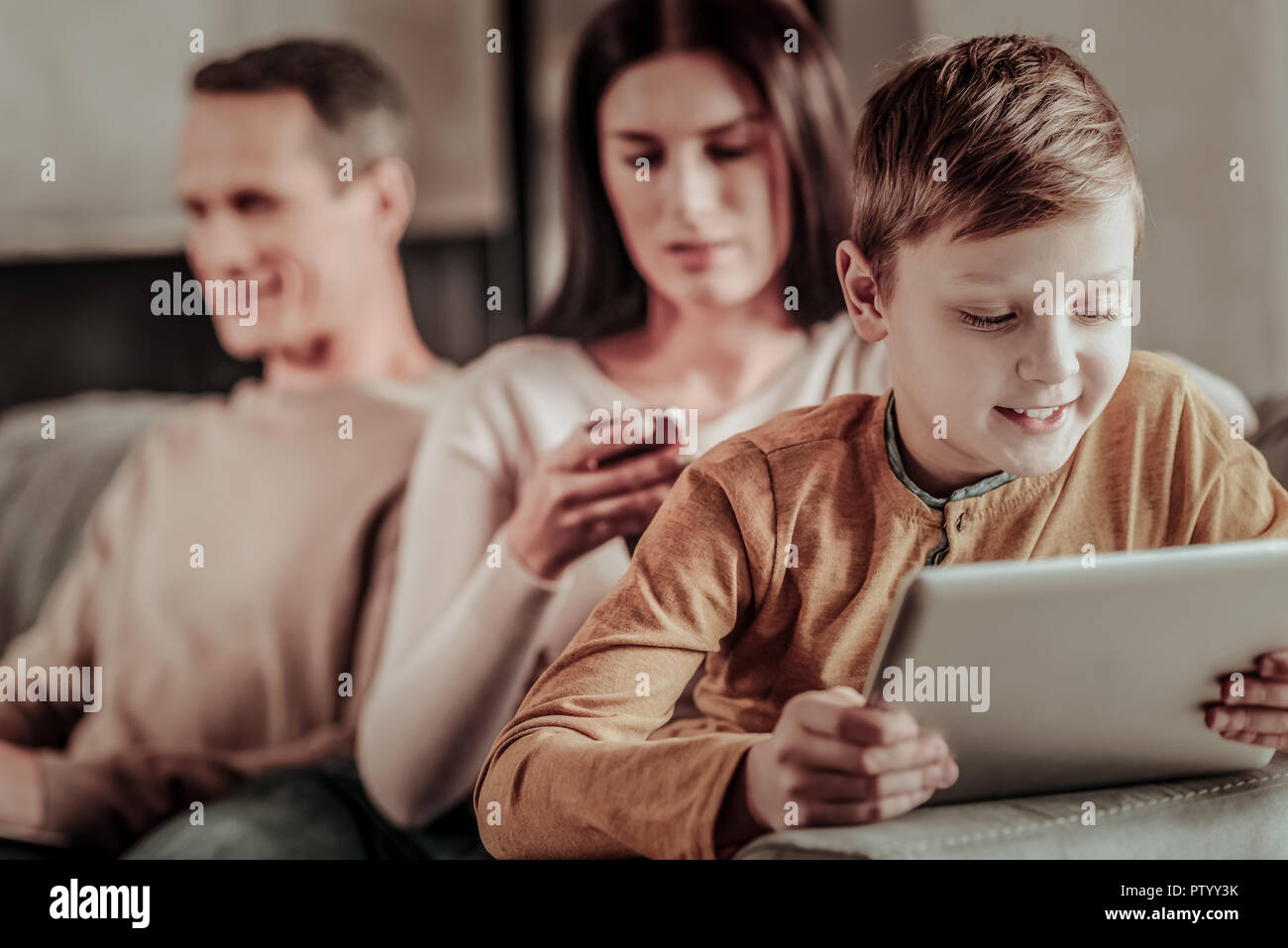 Concentrated kid staring at screen of his tablet Stock Photo - Alamy