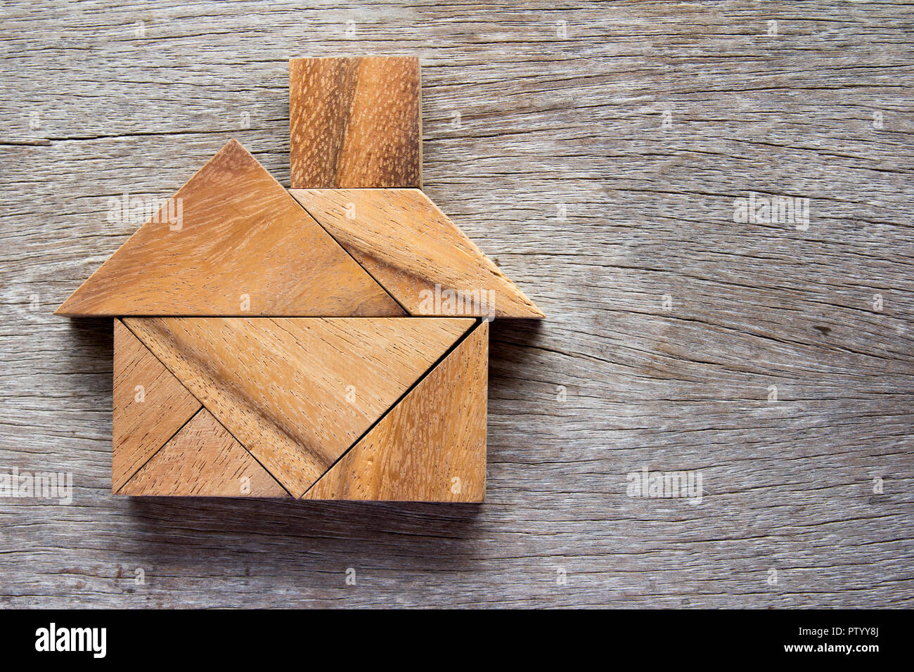 Wooden tangram puzzle in home shape for dream home or happy life ...