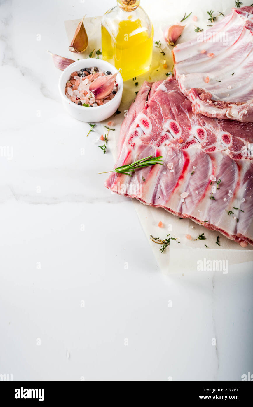 Raw meat, pork ribs with herbs and spices, white marble background copy ...