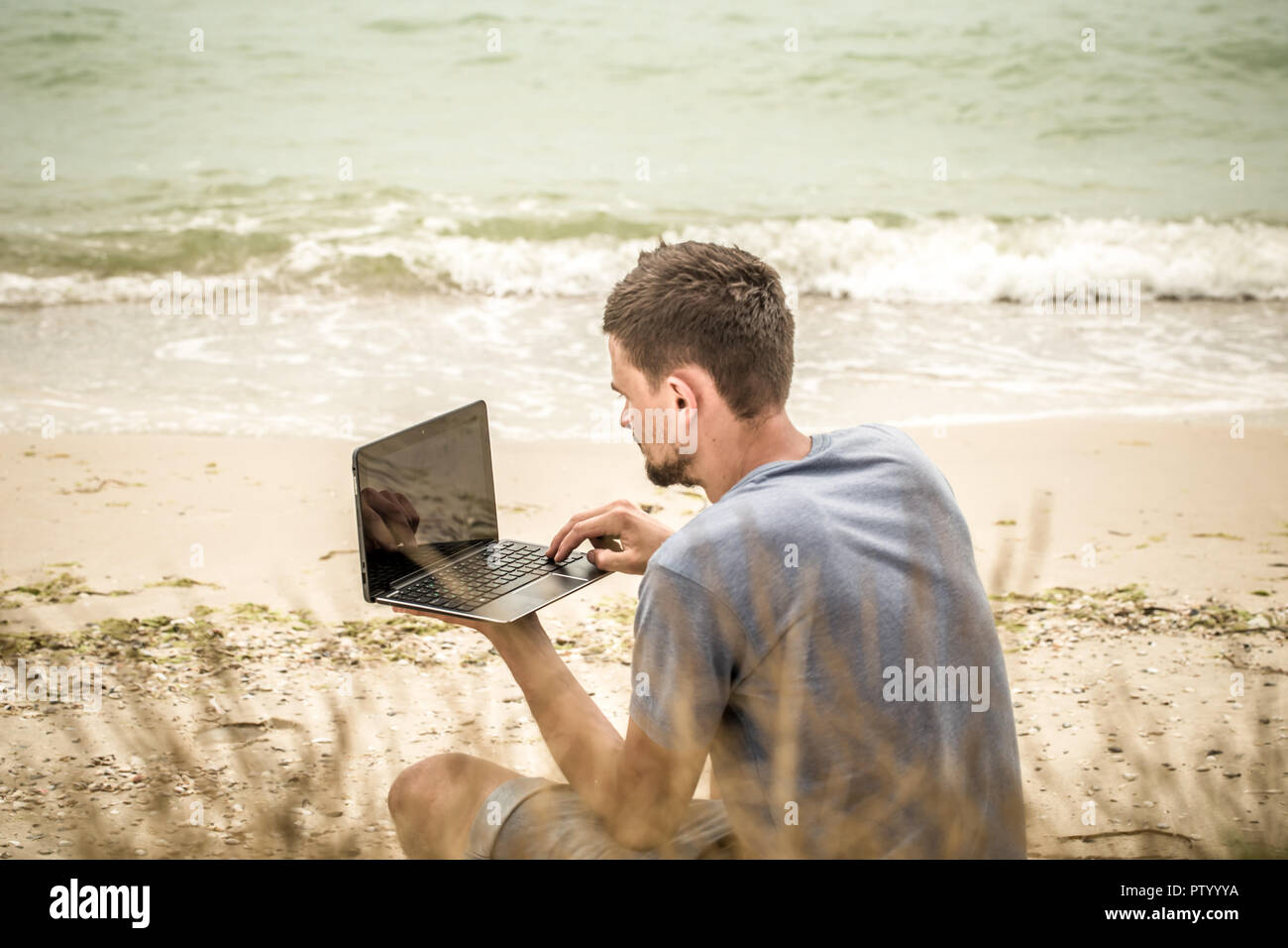 man running on the computer, in nature, to work on the beach Stock ...
