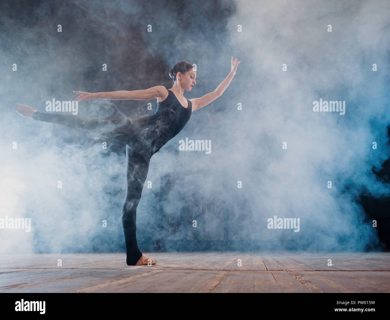 Young beautiful ballerina on smoke stage dancing modern ballet ...