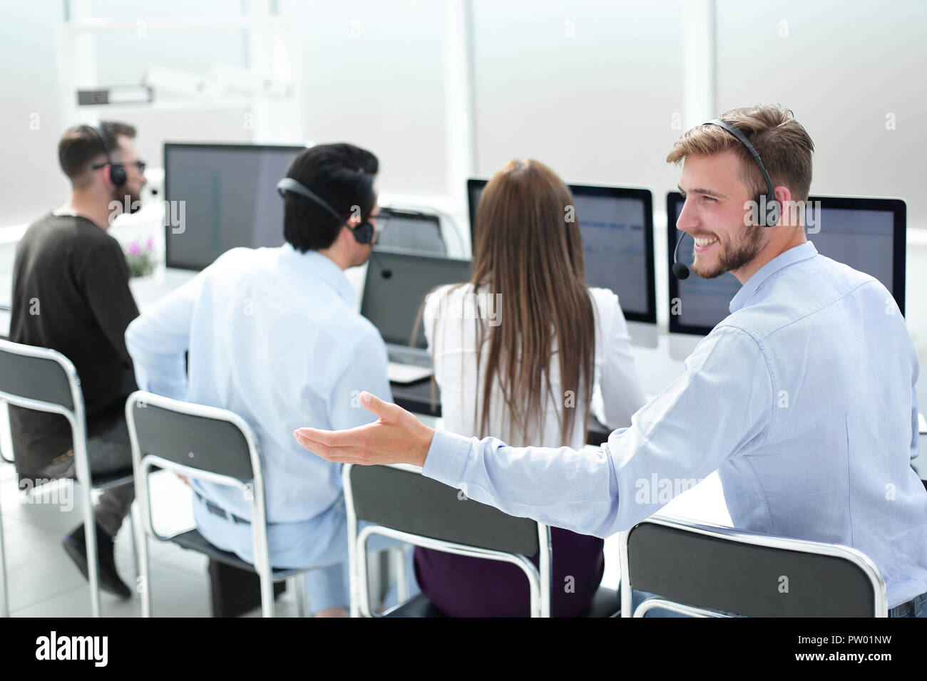 rear view. young customer service agent sitting at his Desk Stock Photo ...