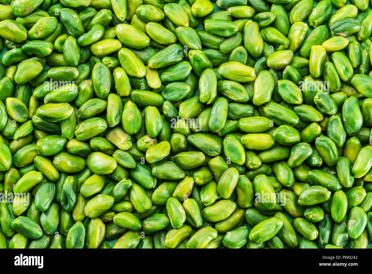 Lot of green pistachio nuts. Food background Stock Photo - Alamy