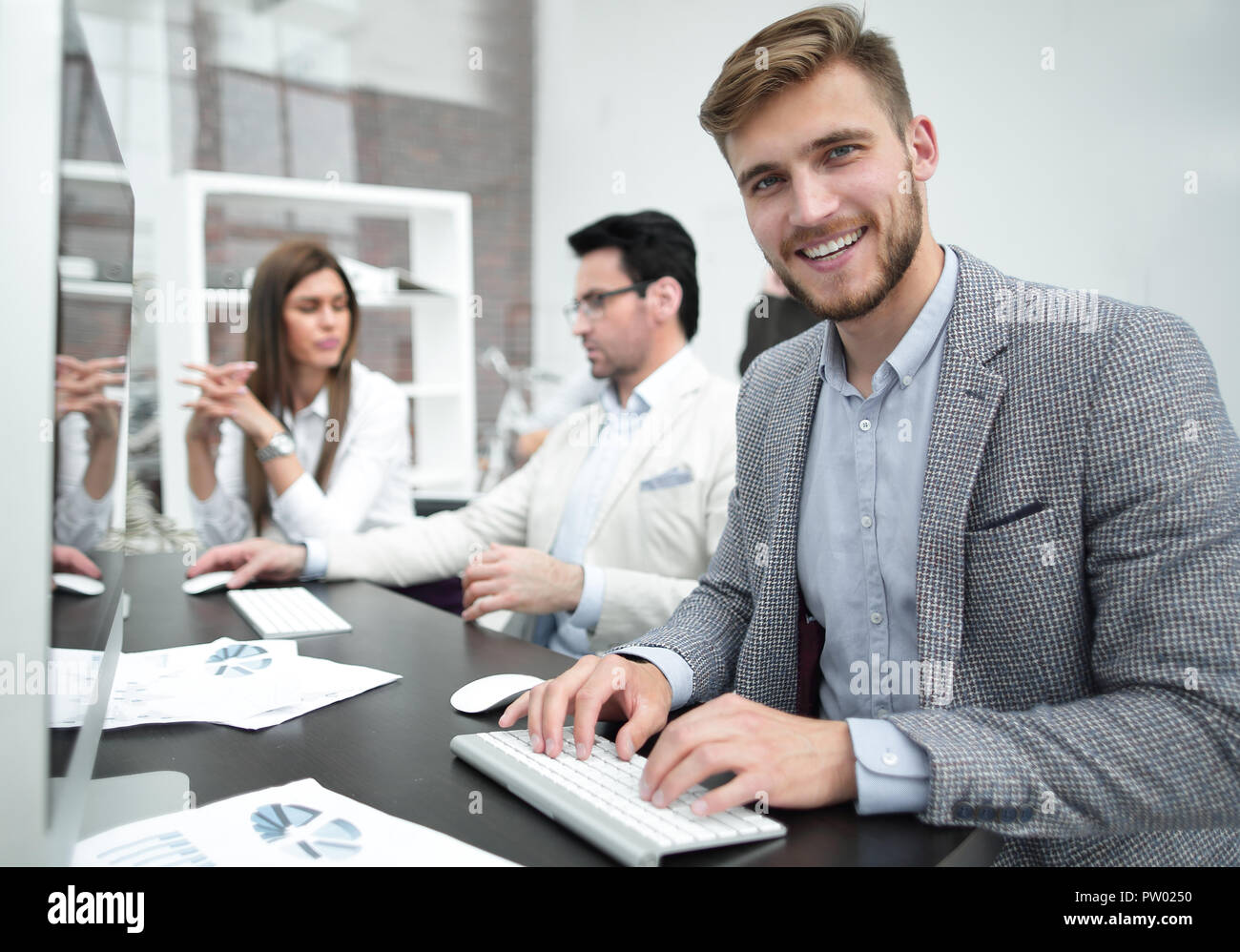 successful employee sitting at the Desk in the office Stock Photo - Alamy