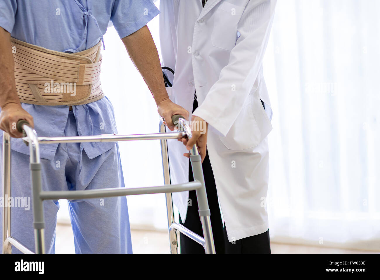 lady doctor help elderly using adult walker in hospital Stock Photo - Alamy