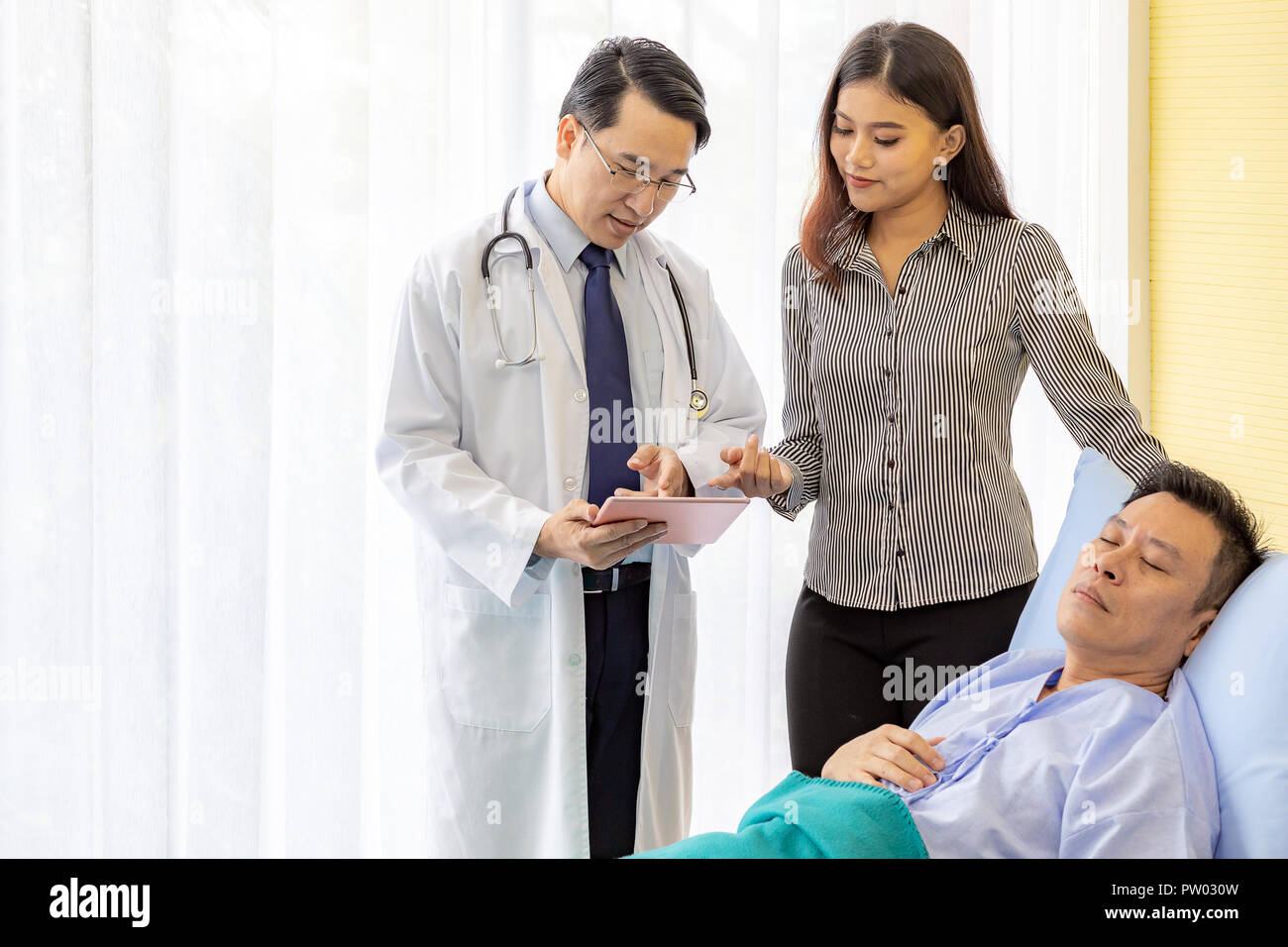 Doctor explaining treatment to patient's relative using tablet Stock ...