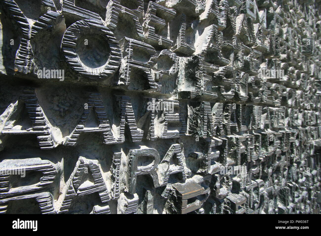 Different letters carved on a stone wall Stock Photo - Alamy